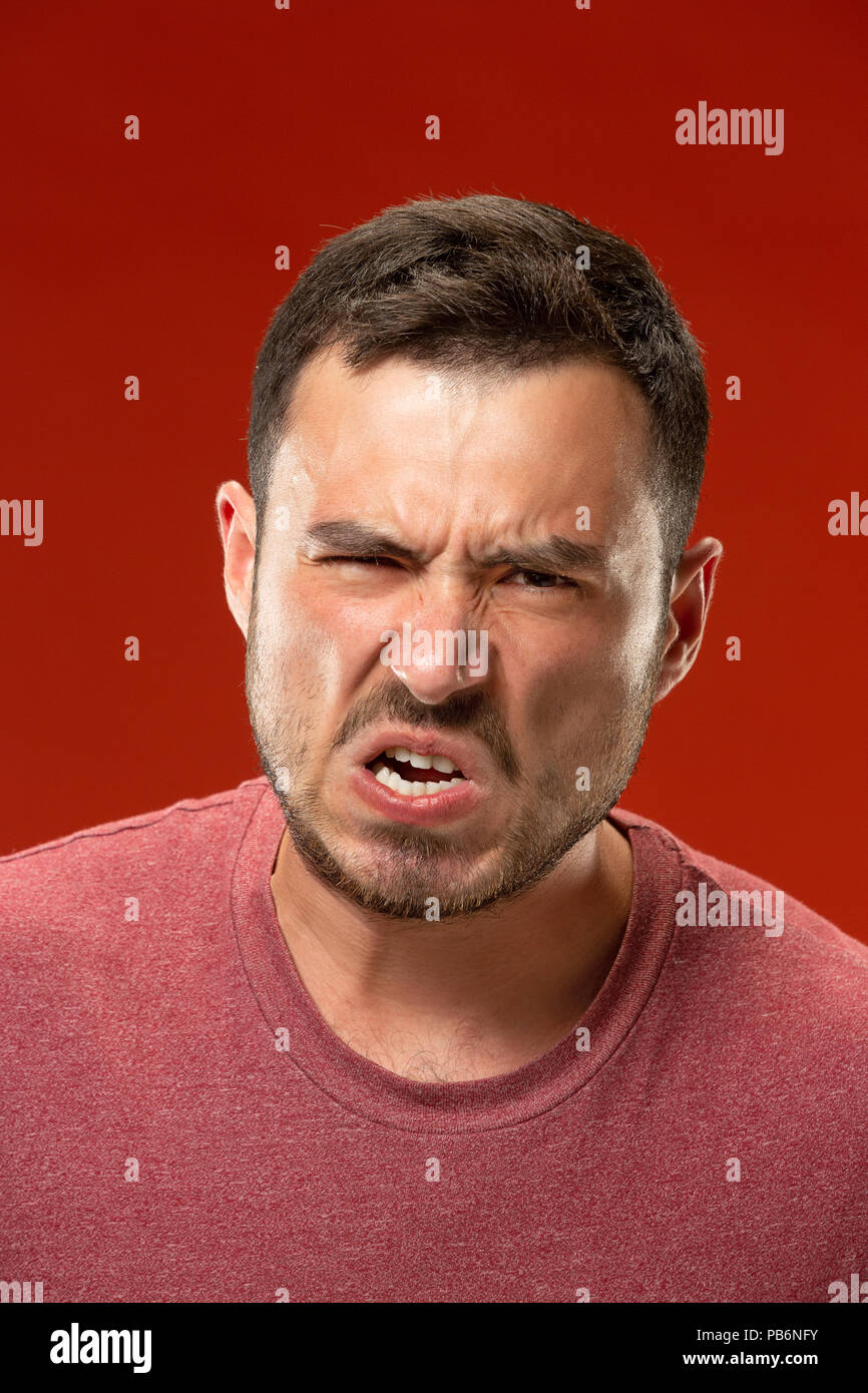 The young emotional angry man screaming on red studio background Stock ...