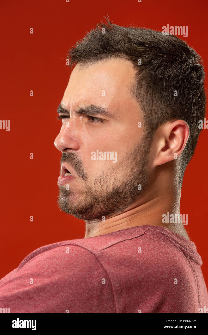 The young emotional angry man screaming on red studio background Stock ...