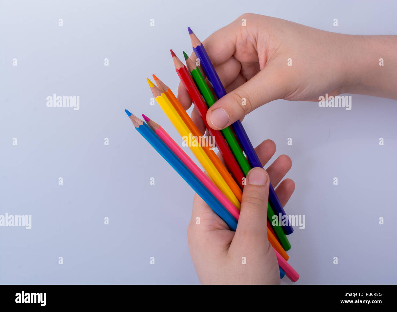 Hand holding color Pencils placed on a white background Stock Photo - Alamy