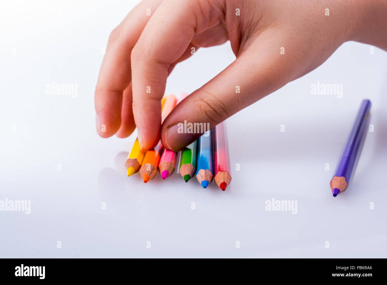 Hand holding color Pencils placed on a white background Stock Photo - Alamy