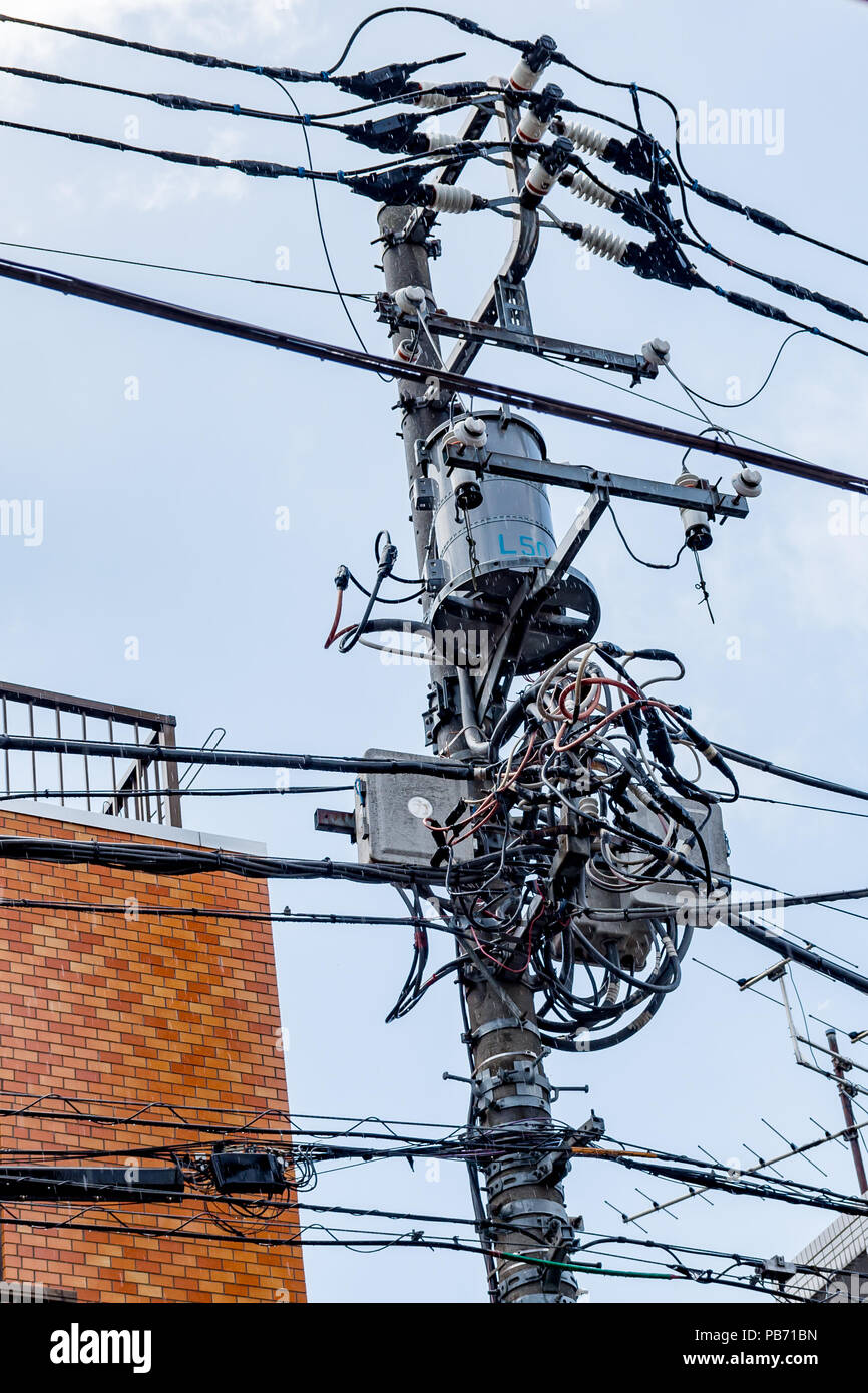 Tangled mess of power cables and junction box on wooden pole in Tokyo ...