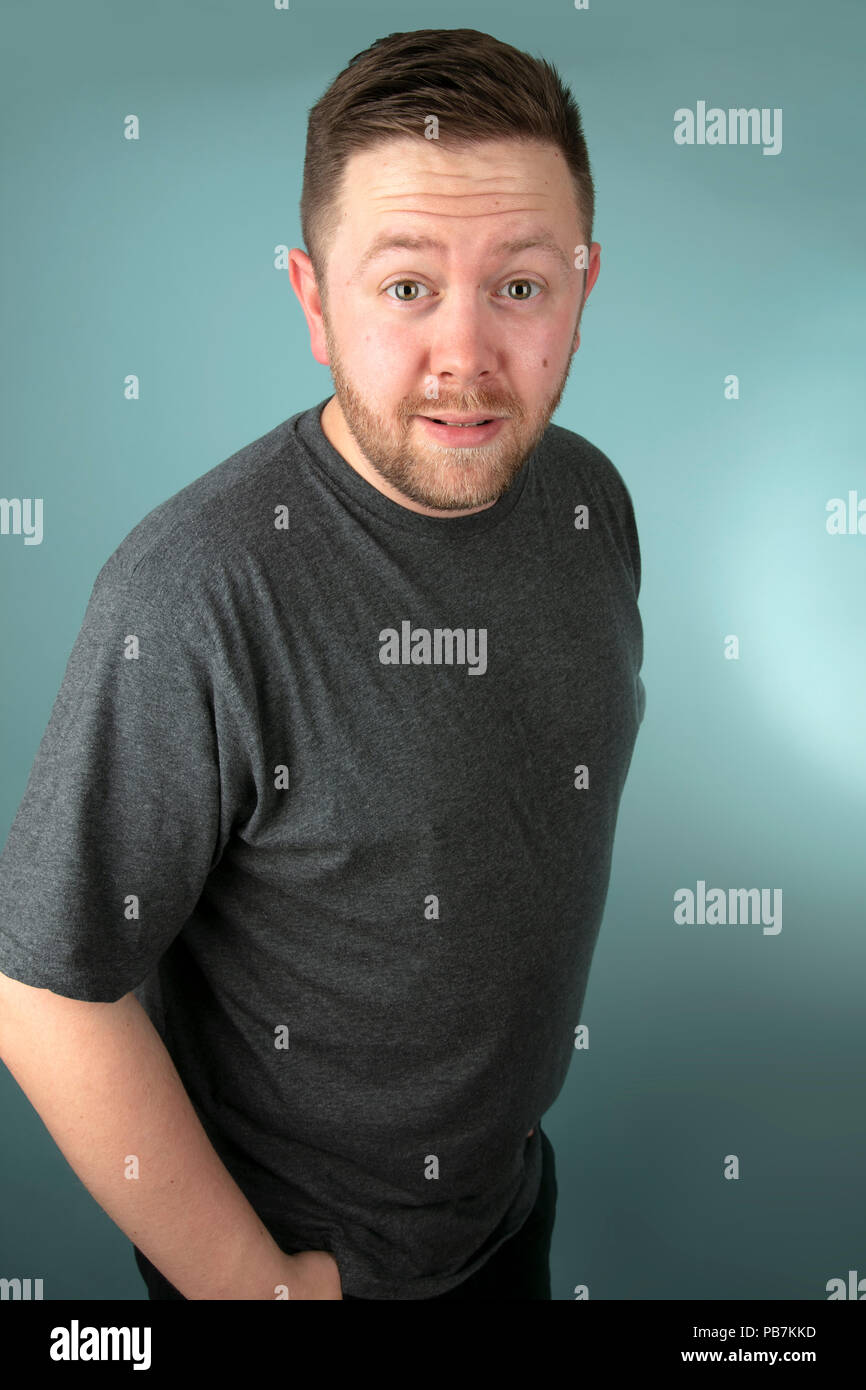 Man leaning forwards staring at the camera in shock, surprise or ...