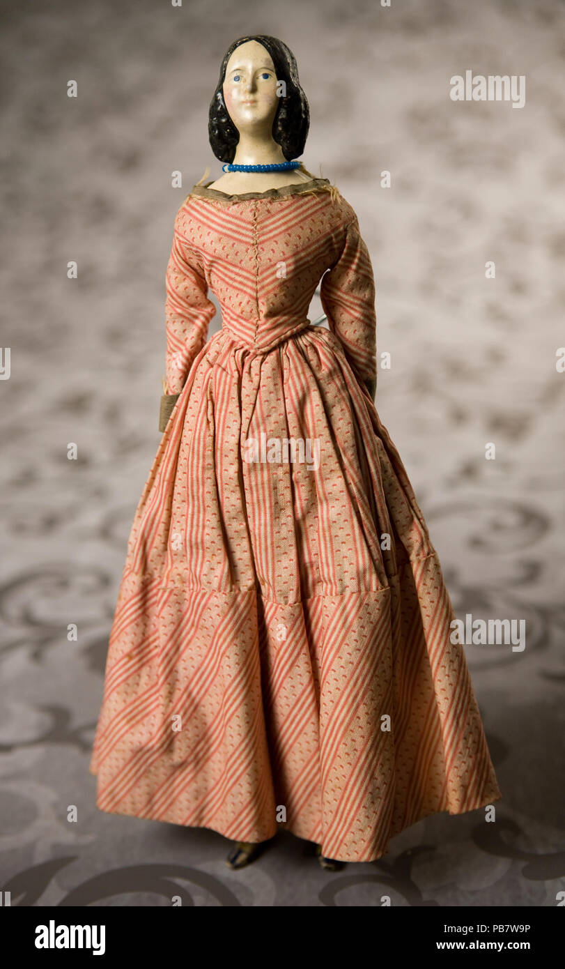 . English: Milliner model doll with papier mache head, wearing a red ...