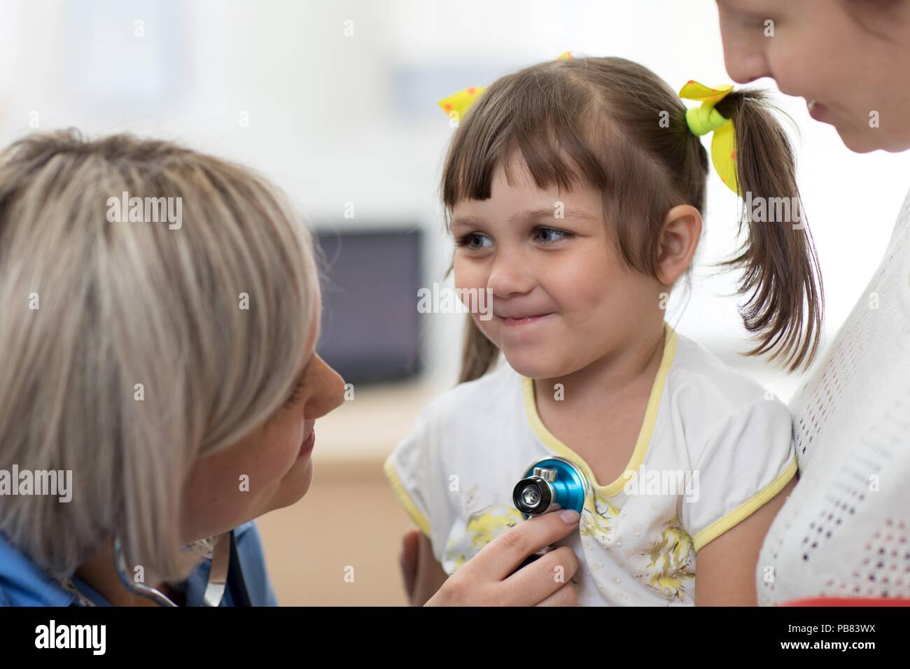 Doctor pediatrician examining kid with stethoscope in clinic. Children ...
