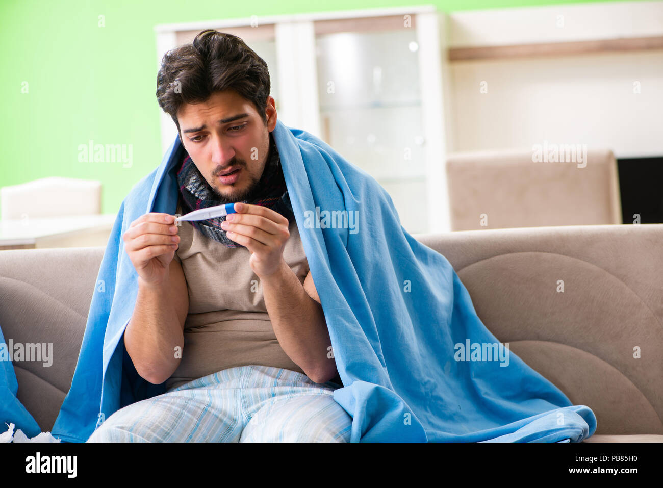 Sick young man suffering from flu at home Stock Photo - Alamy