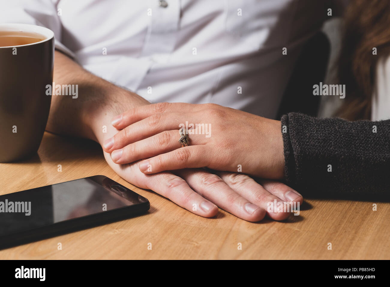 On a table the male hand lies, and from above it is caressed by a ...