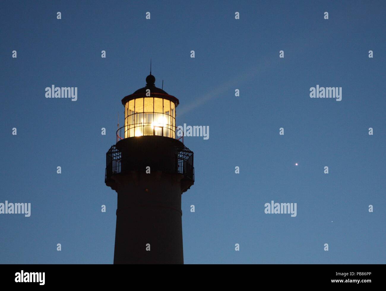 Cape May Lighthouse beaming light at dusk, Cape May Point State Park ...