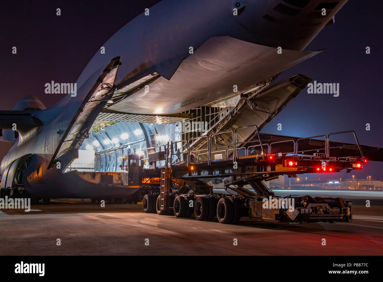 U.S. Airmen with the 60th Aerial Port Squadron load cargo onto a C-5M ...