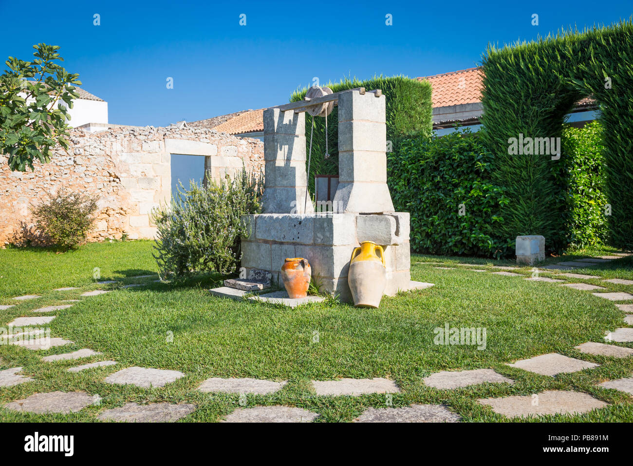 Summer season in Italy. Desing water well in an elegant garden Stock ...