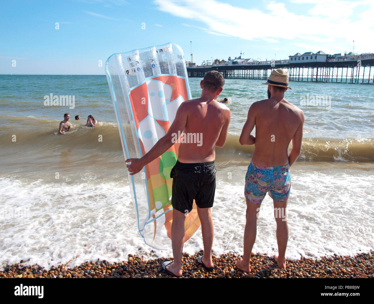 About to enter the water with a lilo on the beach at Brighton Stock ...