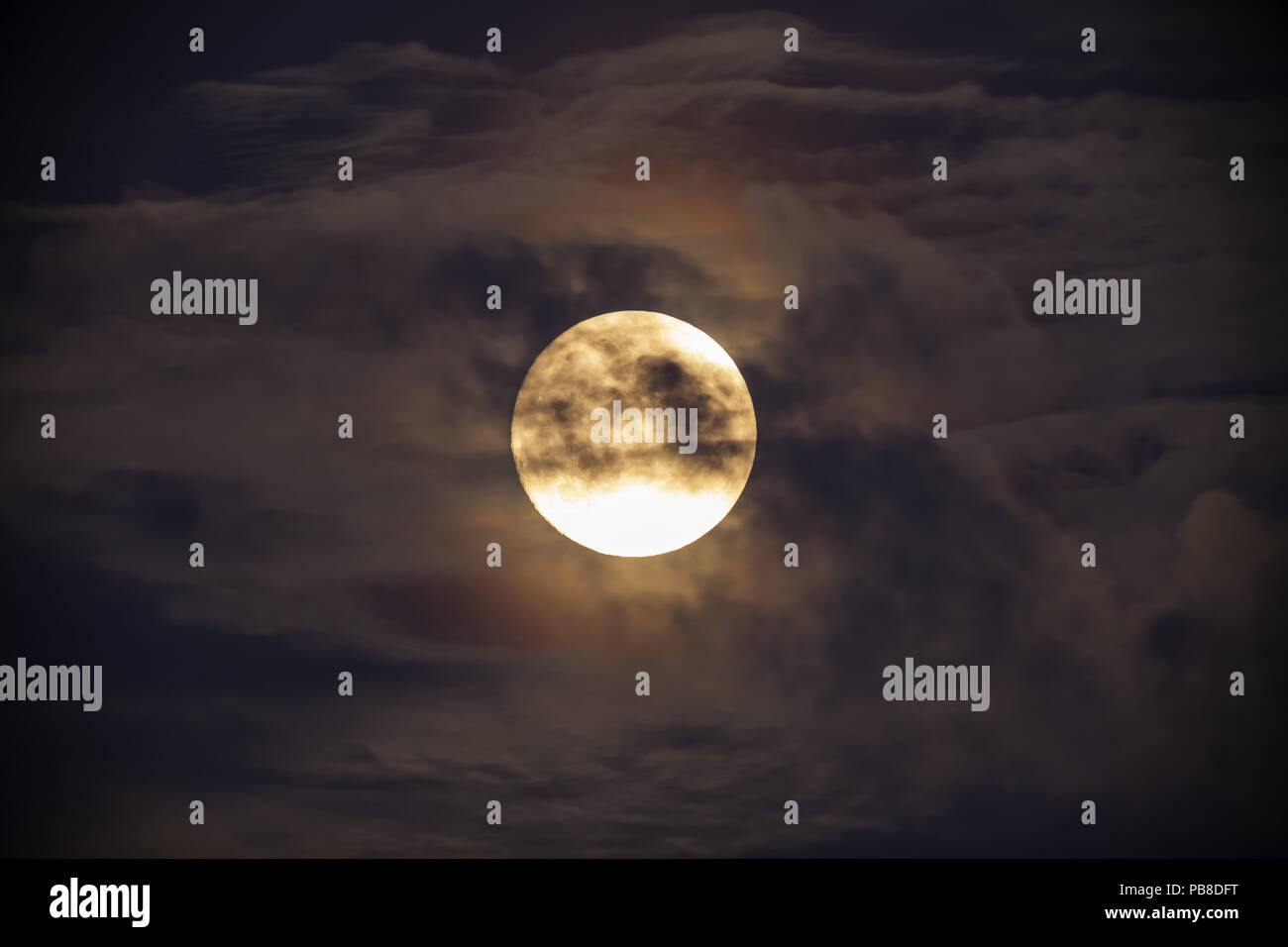 Bright full moon against dark clouds Stock Photo - Alamy