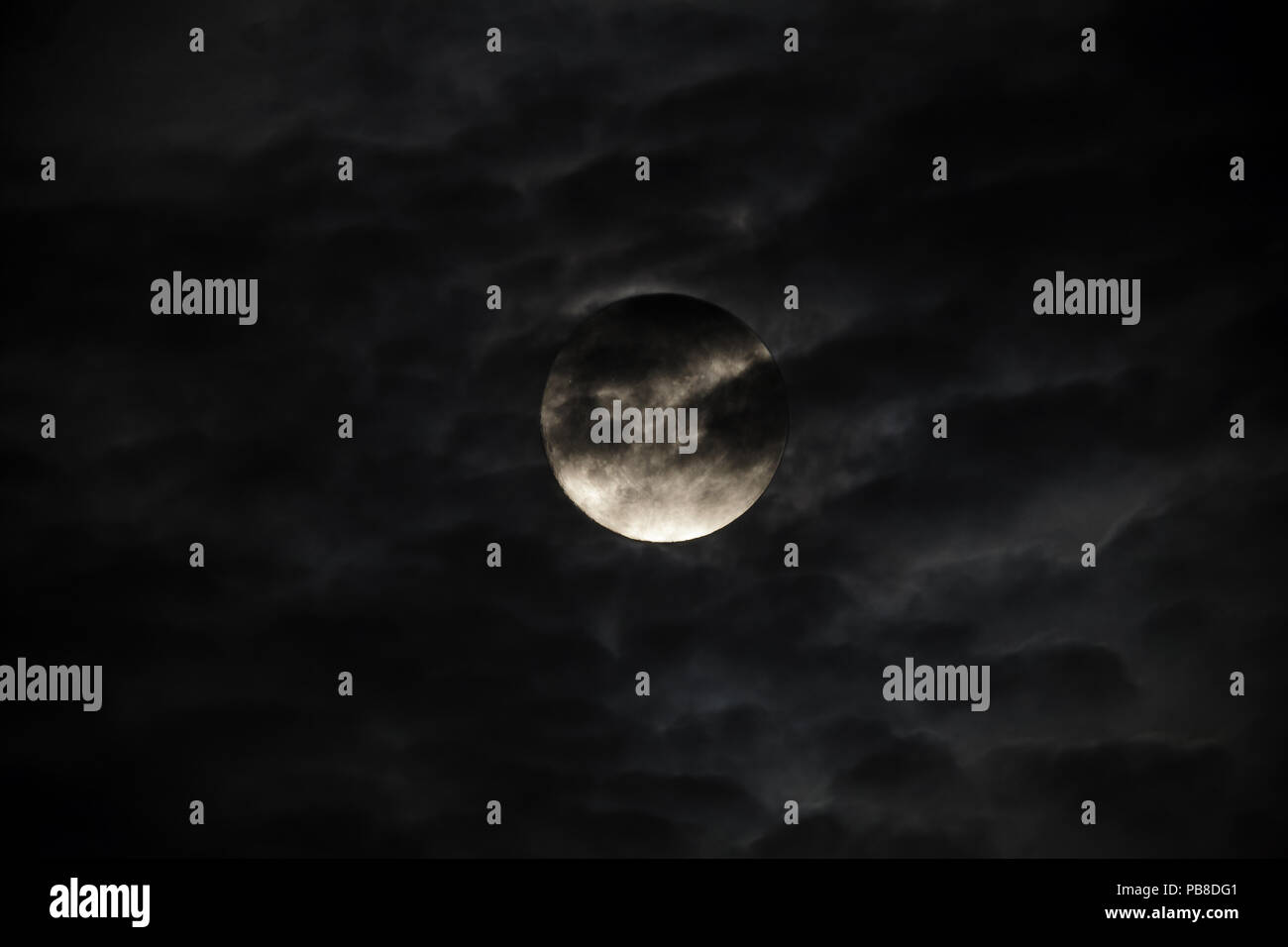 Bright full moon against dark clouds Stock Photo - Alamy