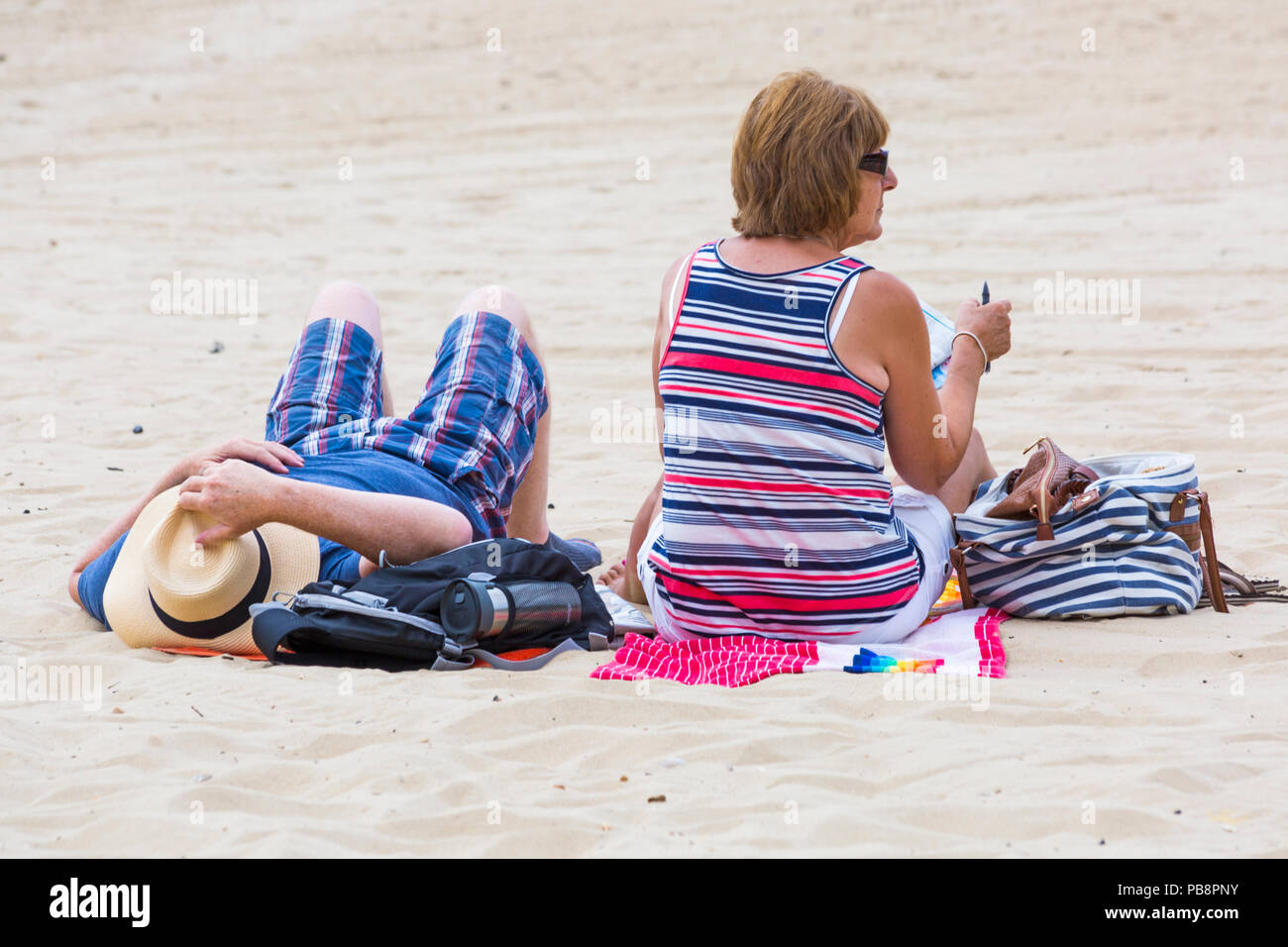 Mature couple sunbathing on beach hi-res stock photography and images ...