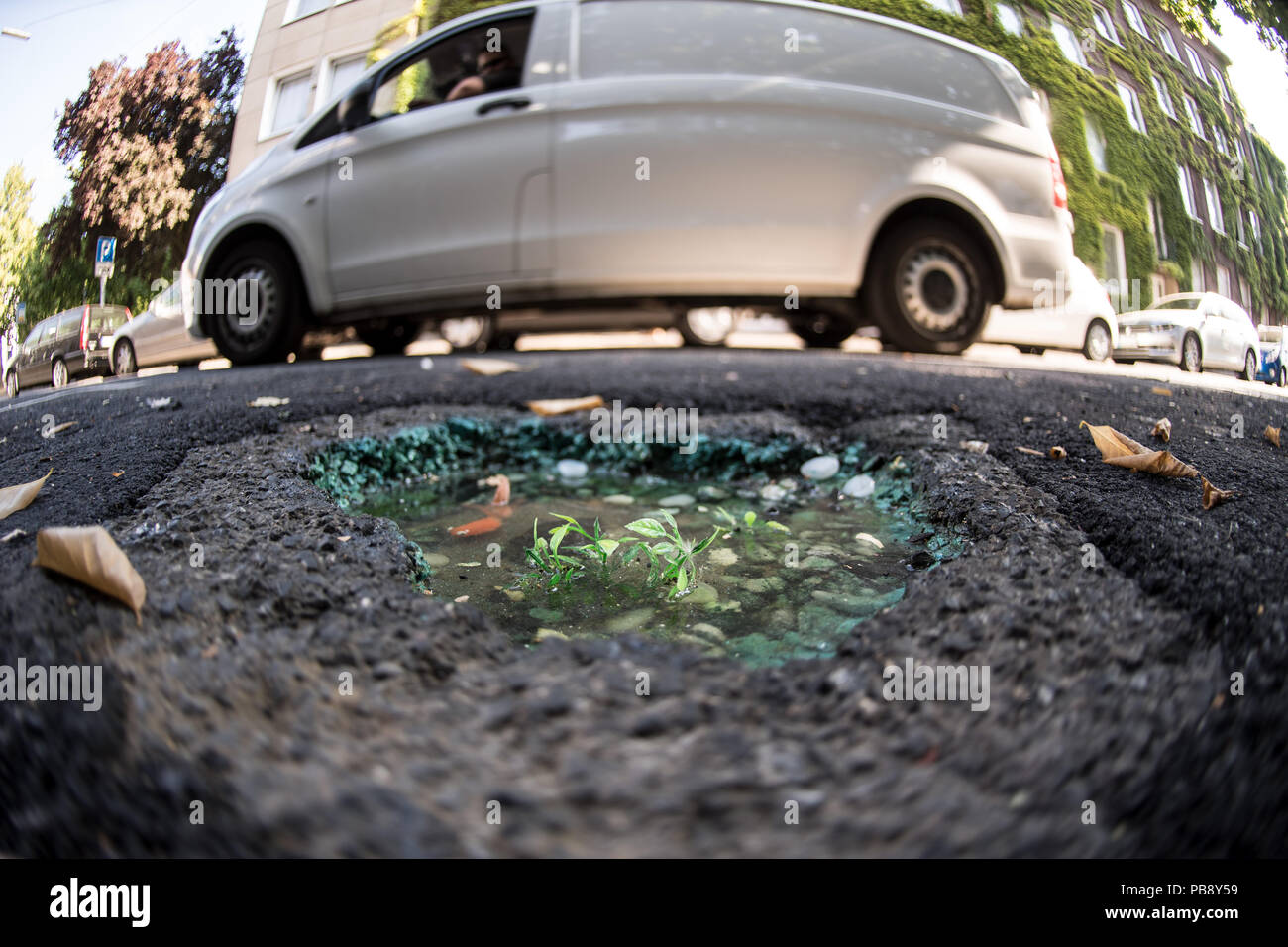 27 June 2018, Germany, Mönchengladbach: A car passes a pothole ...
