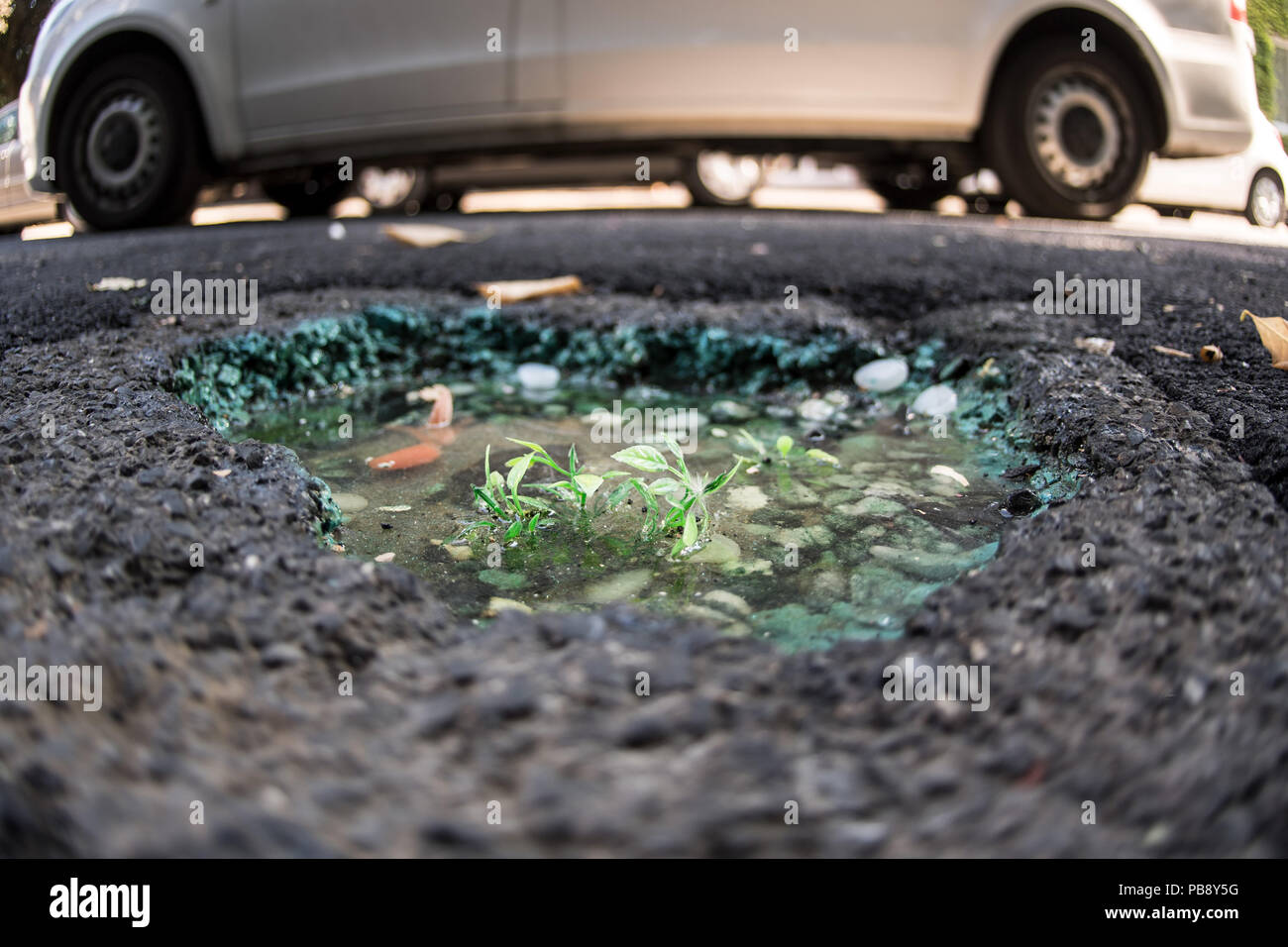 27 June 2018, Germany, Mönchengladbach: A car passes a pothole ...