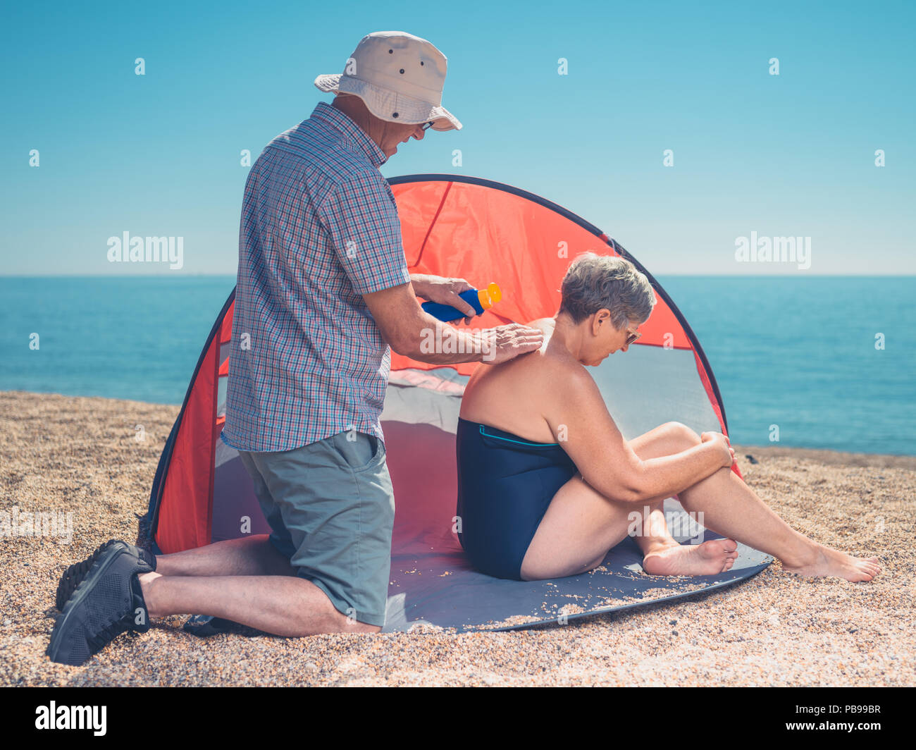 A senior man is applying sun cream to his wife's back Stock Photo - Alamy