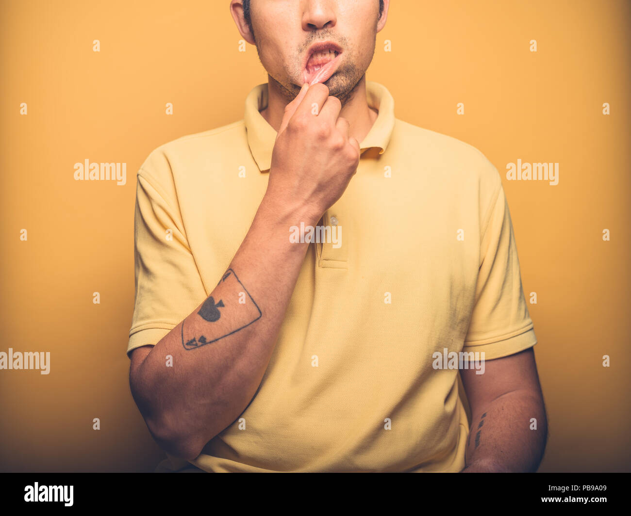 A young man is pulling his lip Stock Photo - Alamy