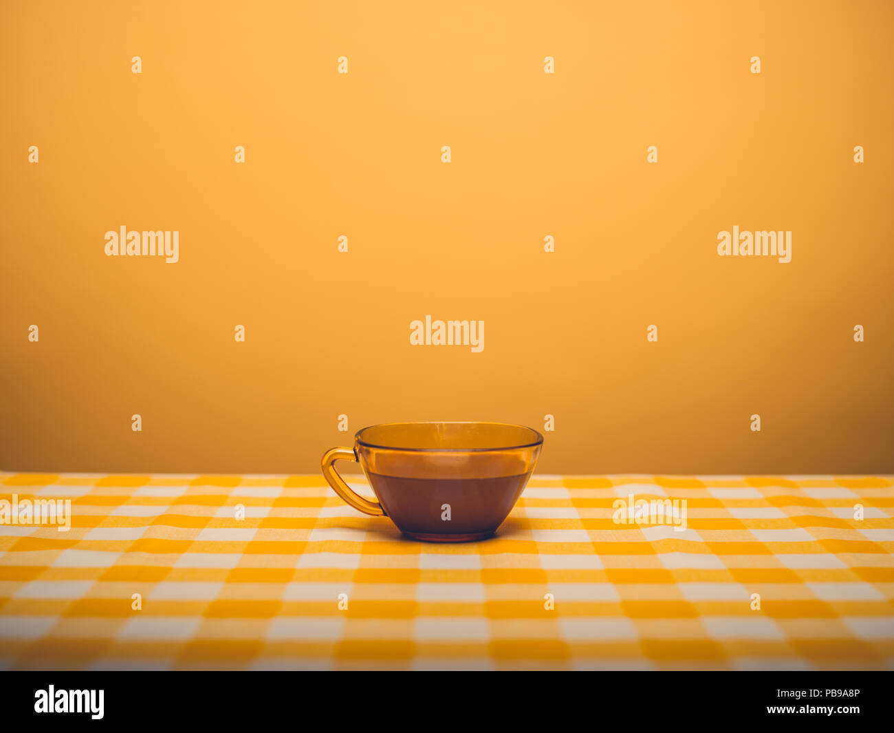 A cup of coffee on a table against yellow Stock Photo - Alamy