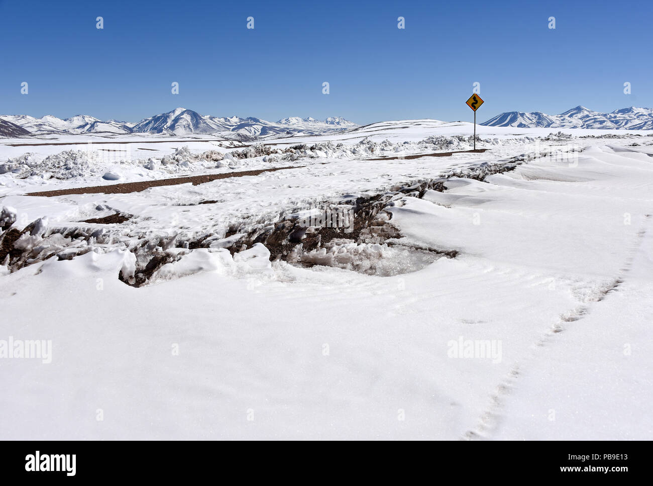 Snow-covered road through Atacama desert with road sign in front of ...