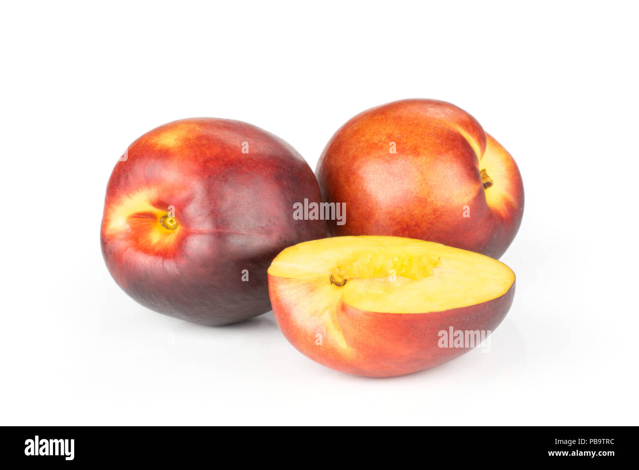Group of two whole one half of ripe deep red nectarine isolated on ...