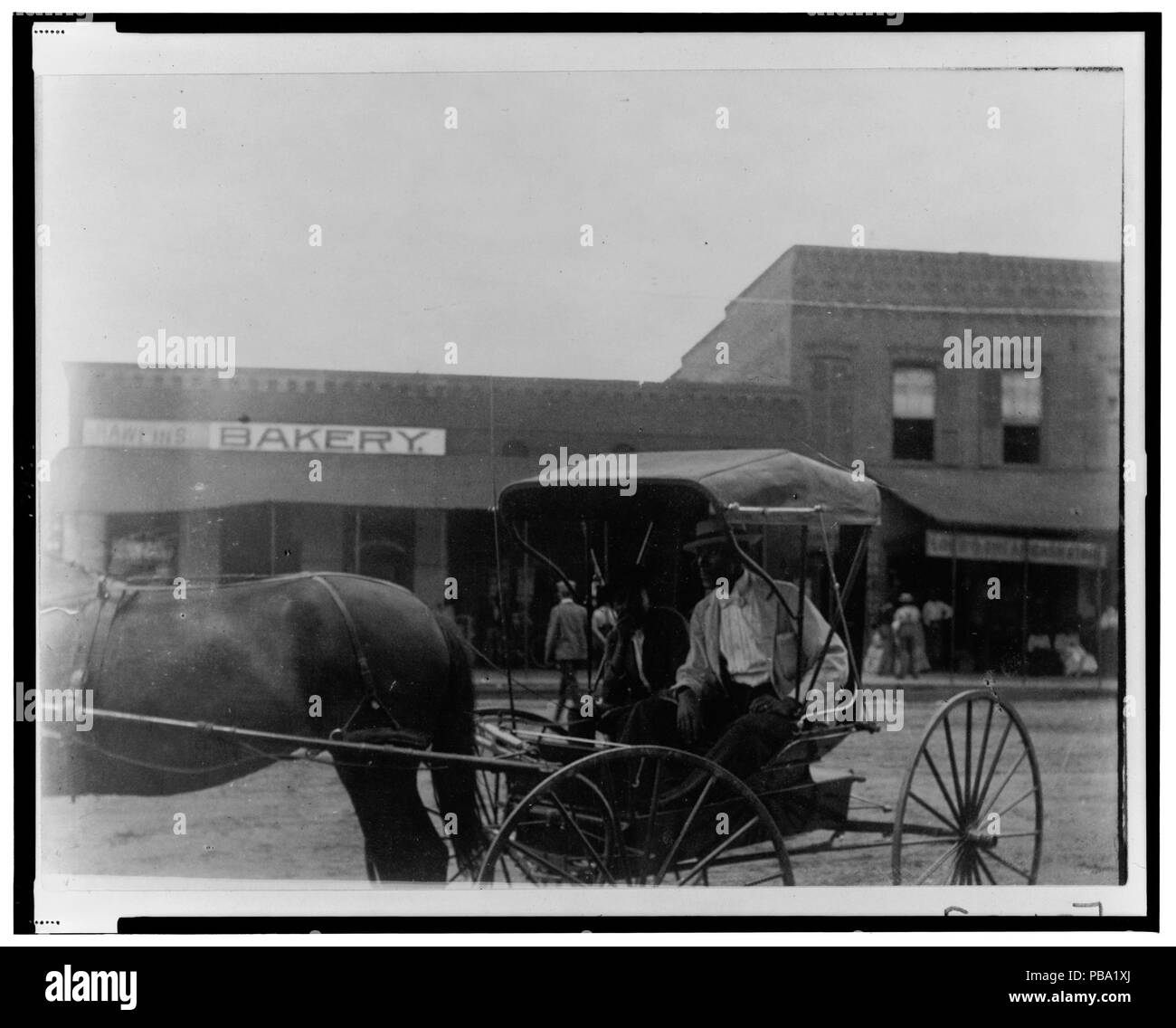 1780 Two African American men sitting in horse-drawn carriage; bakery ...