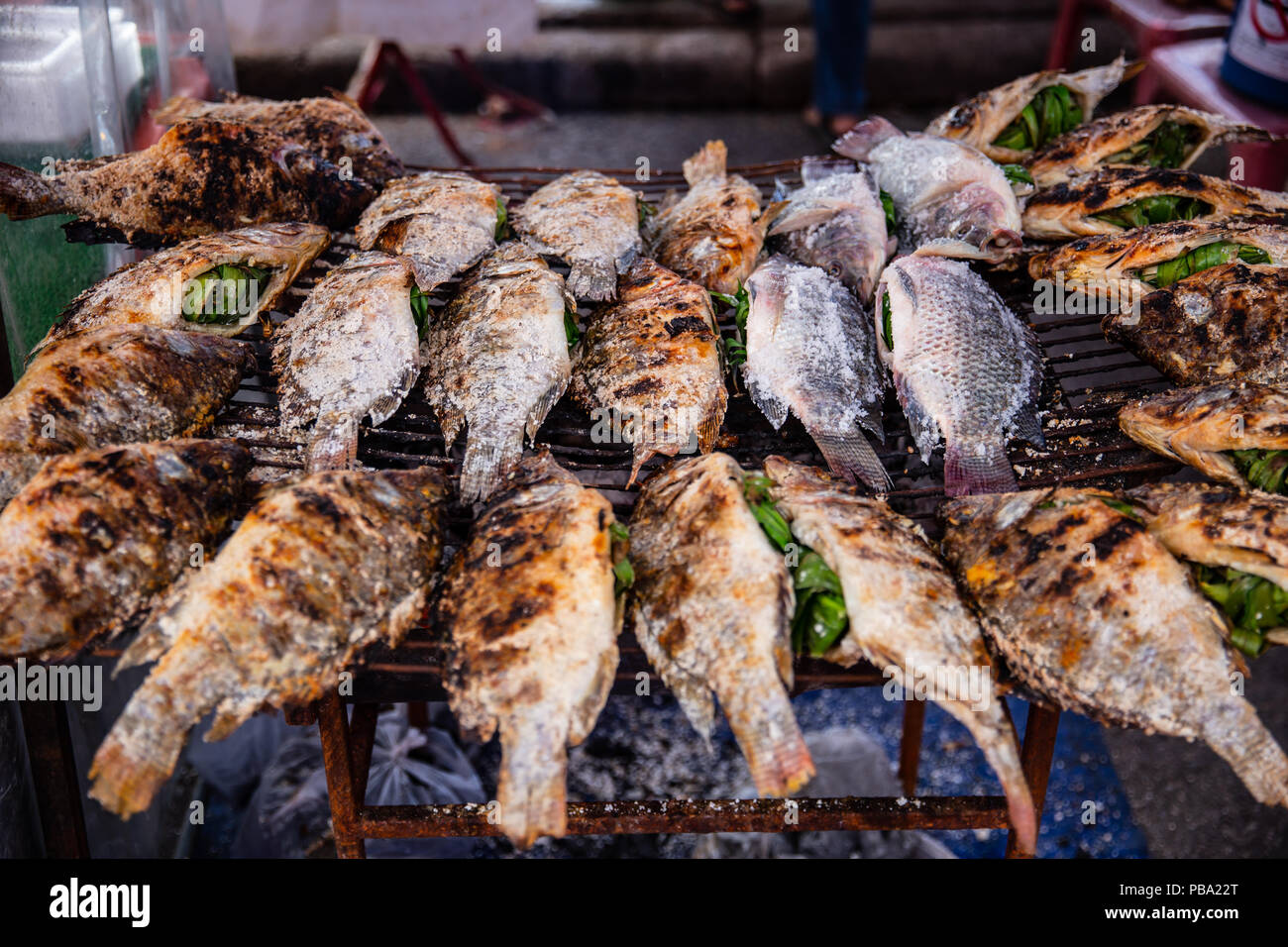 Thai Fish cooking grill with salt on charcoal fire Stock Photo - Alamy