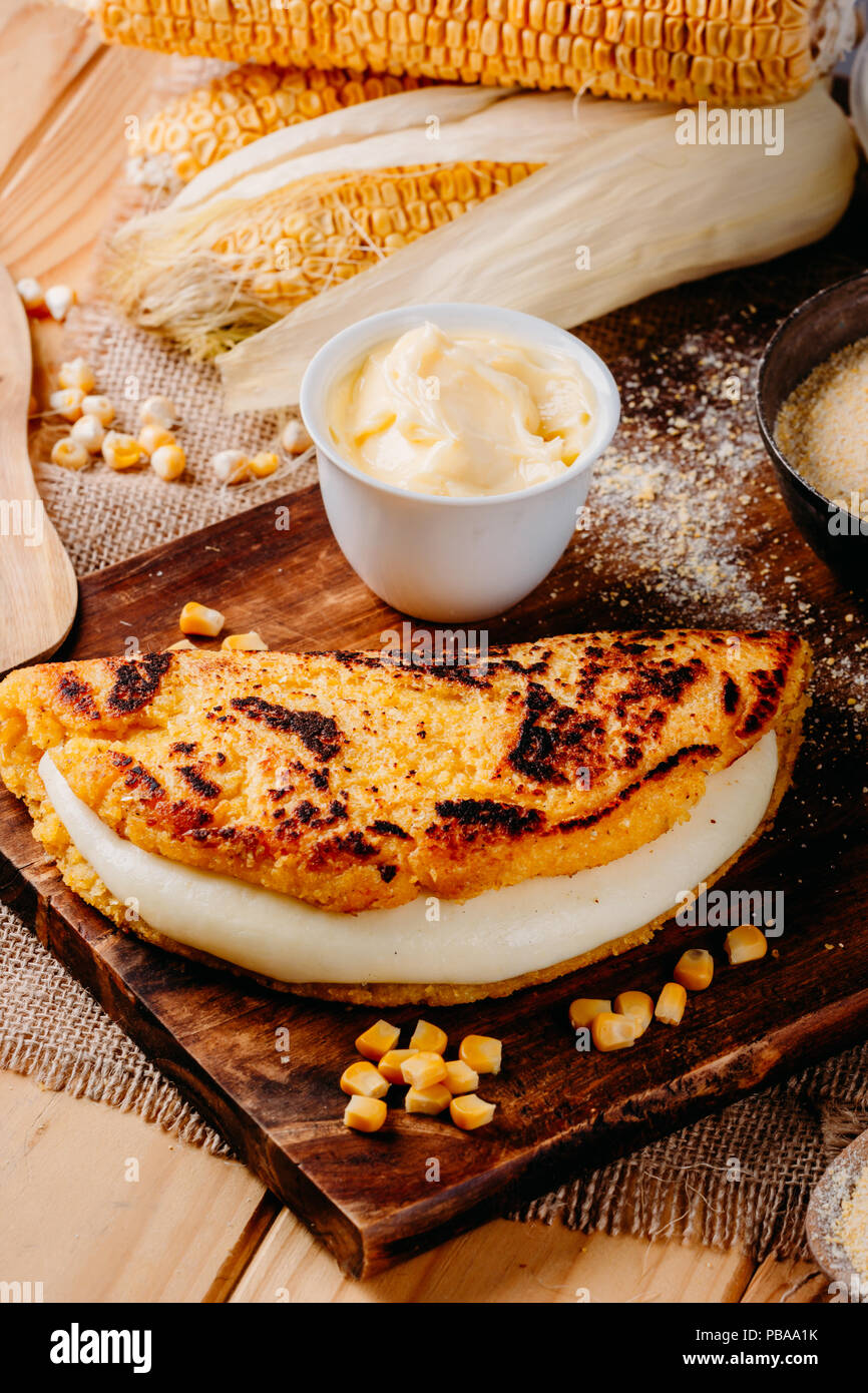 Wooden table with several ingredients for the preparation of Cachapas ...