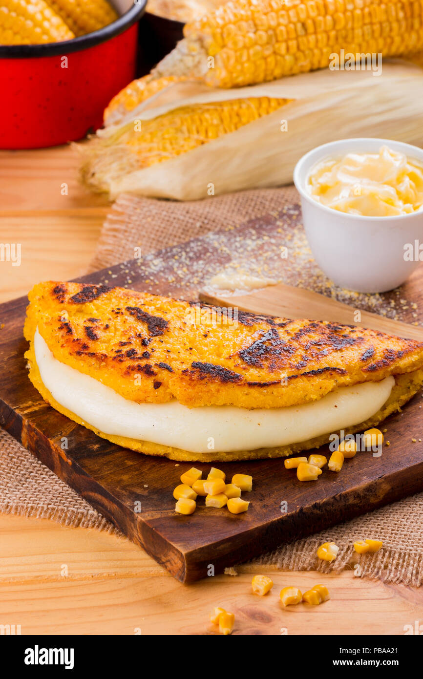 Wooden table with several ingredients for the preparation of Cachapas ...