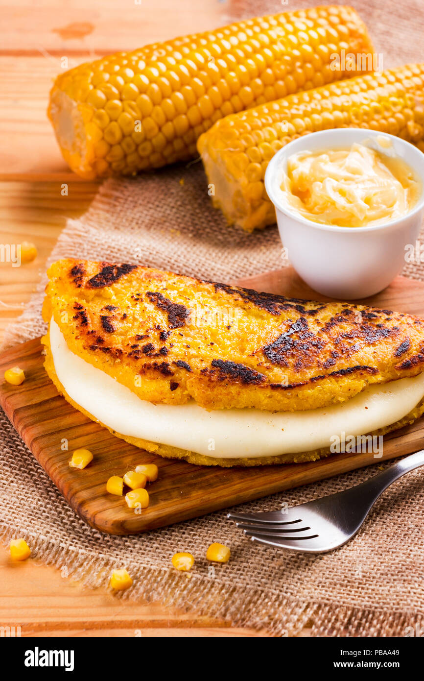 Wooden table with several ingredients for the preparation of Cachapas ...