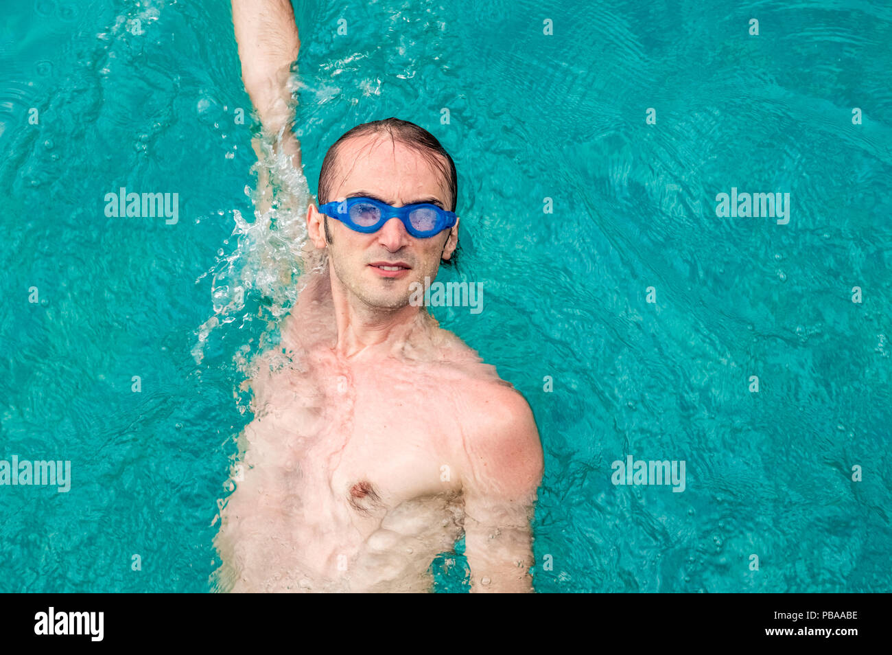 Top view of a young Caucasian man swimming back crawl in a swimming ...