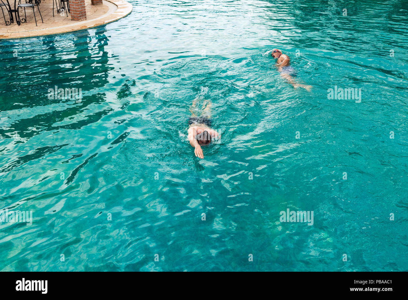 Top view of two Caucasian men swimming front crawl in a swimming pool ...