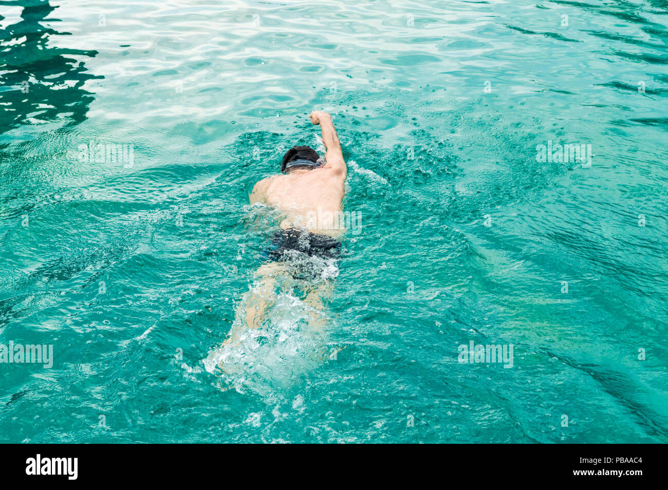 Top view of a young Caucasian man swimming front crawl in a swimming ...