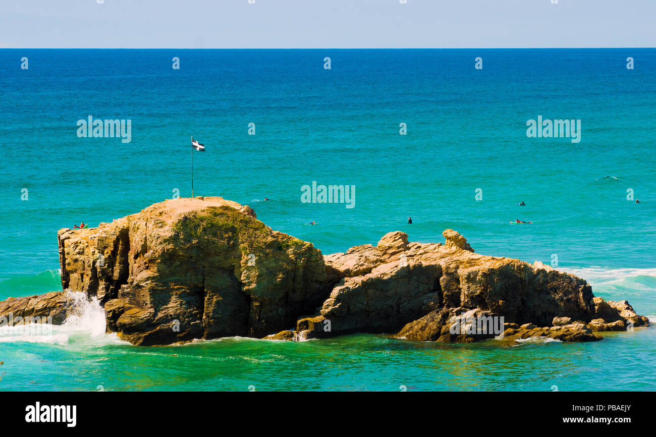 The Cornish St Piran's flag proudly flies from a rock formation on ...