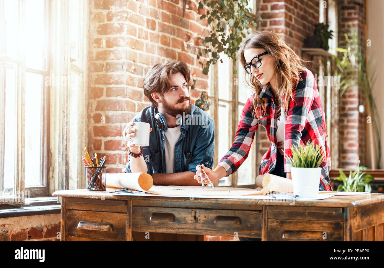 Female ambitious architect in glasses showing an architectural plan to ...