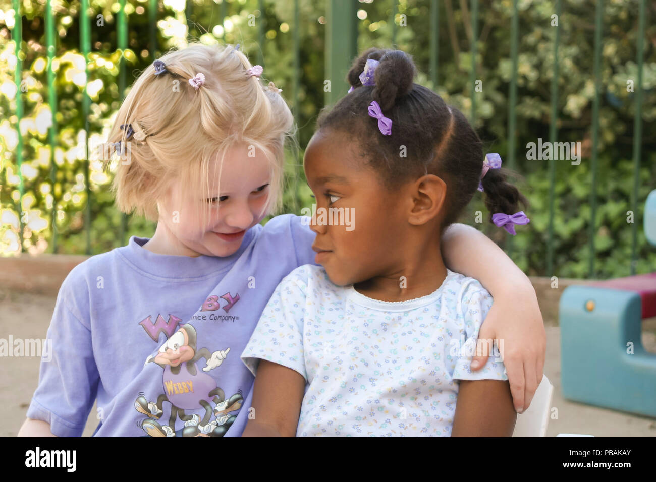 Kindergarten girl comforts friend on playground Stock Photo - Alamy