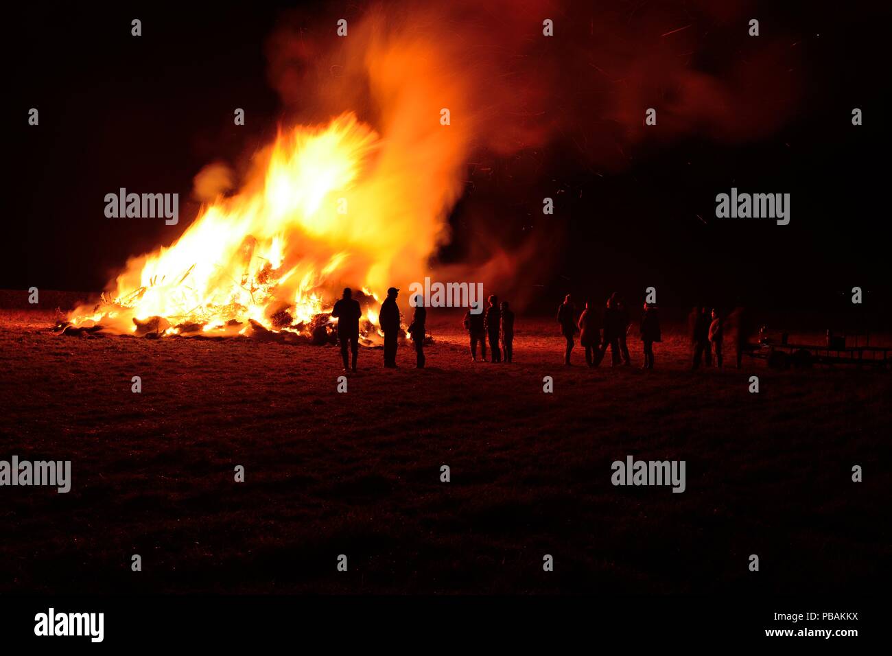 Photo of a group of people standing around a bonfire on bonfire night ...