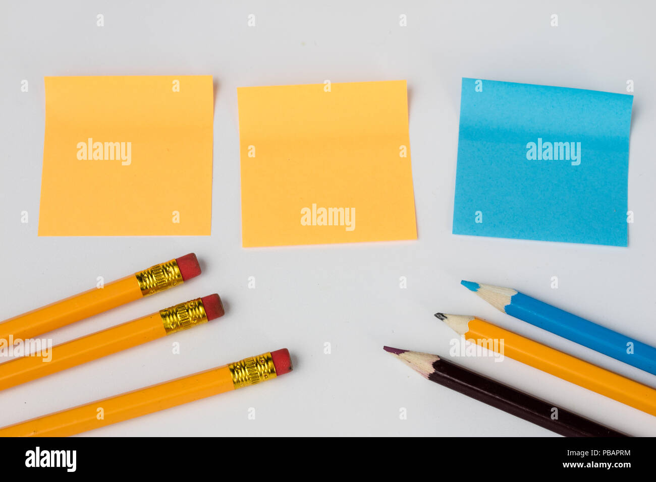 Pencil and sticky notes on a white table. Office accessories for saving ...