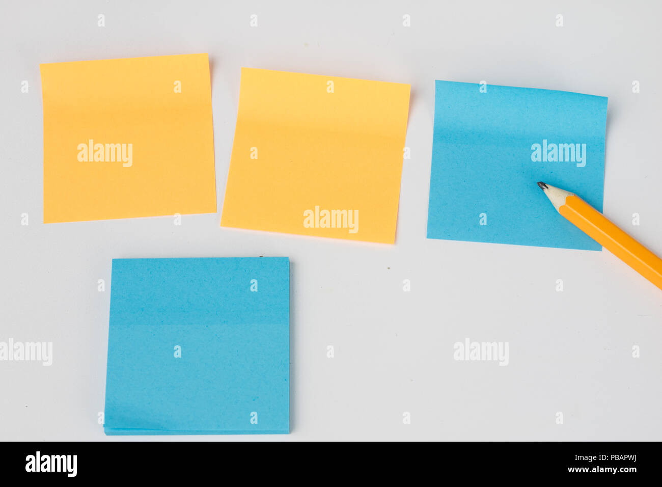 Pencil and sticky notes on a white table. Office accessories for saving ...