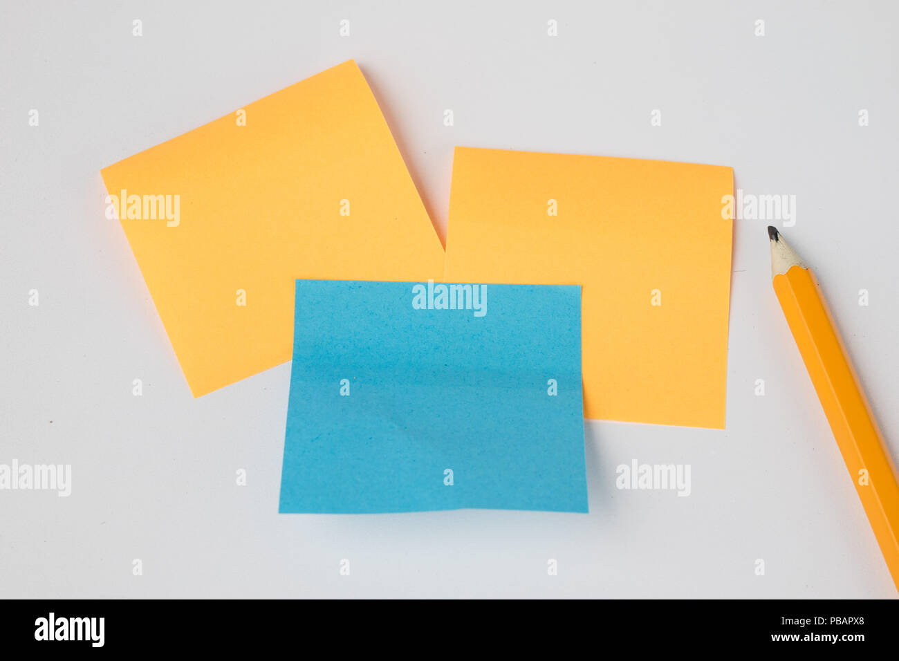 Pencil and sticky notes on a white table. Office accessories for saving ...