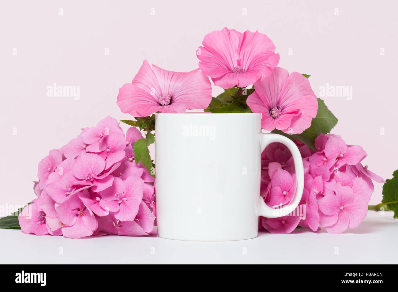 blank white coffee mug mock up with pink flowers Stock Photo - Alamy