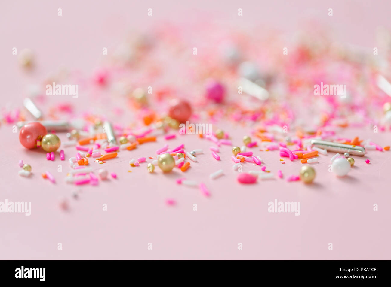 Colorful pink sprinkle blend on a pink background Stock Photo - Alamy