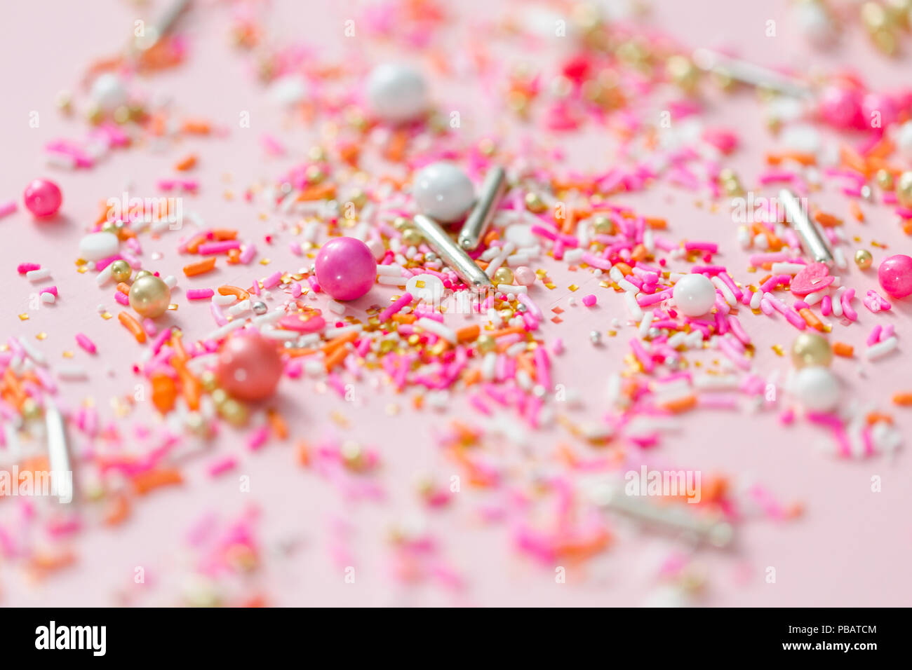 Colorful pink sprinkle blend on a pink background Stock Photo - Alamy