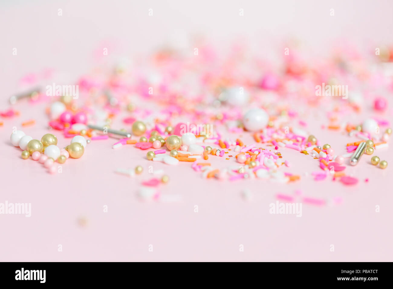 Colorful pink sprinkle blend on a pink background Stock Photo - Alamy