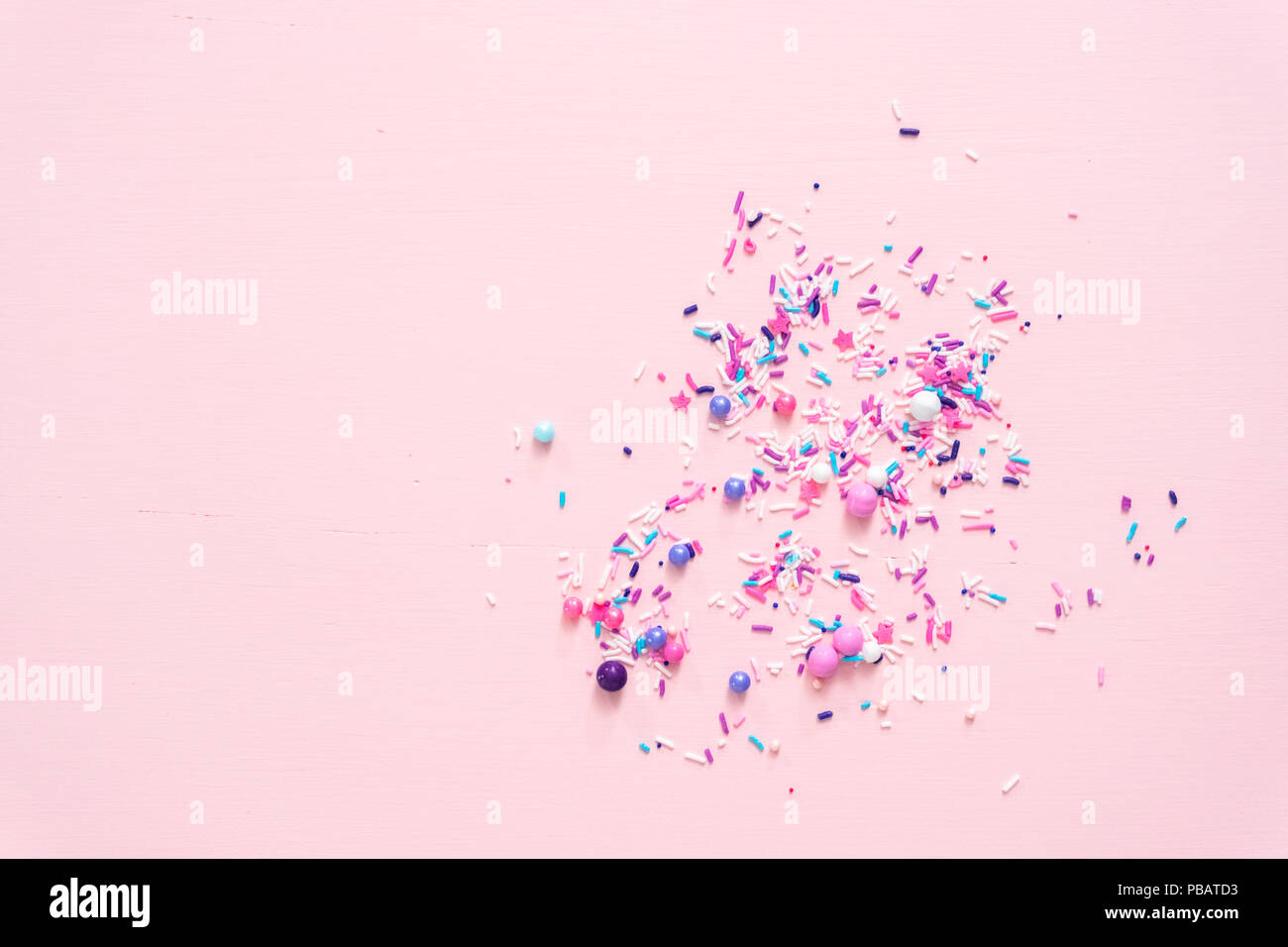 Colorful purple sprinkle blend on a pink background Stock Photo - Alamy