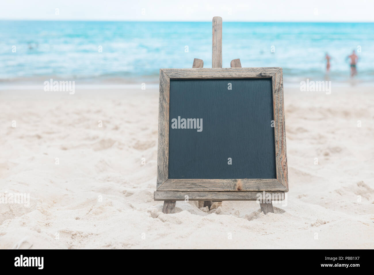 Chalk board with sunscreen cream in the sand on the beach tropic exotic ...