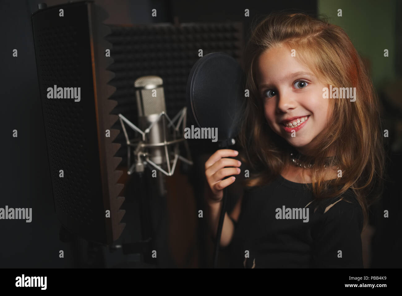 little happy girl singing in recording studio Stock Photo - Alamy