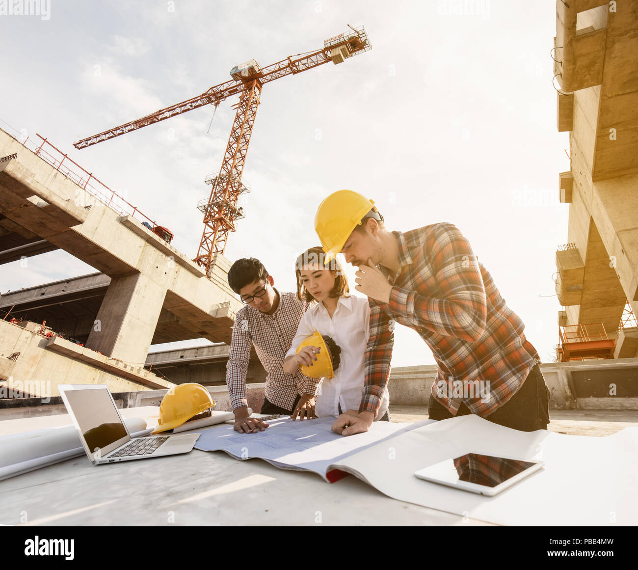 three construction engineers working together in construction site ...