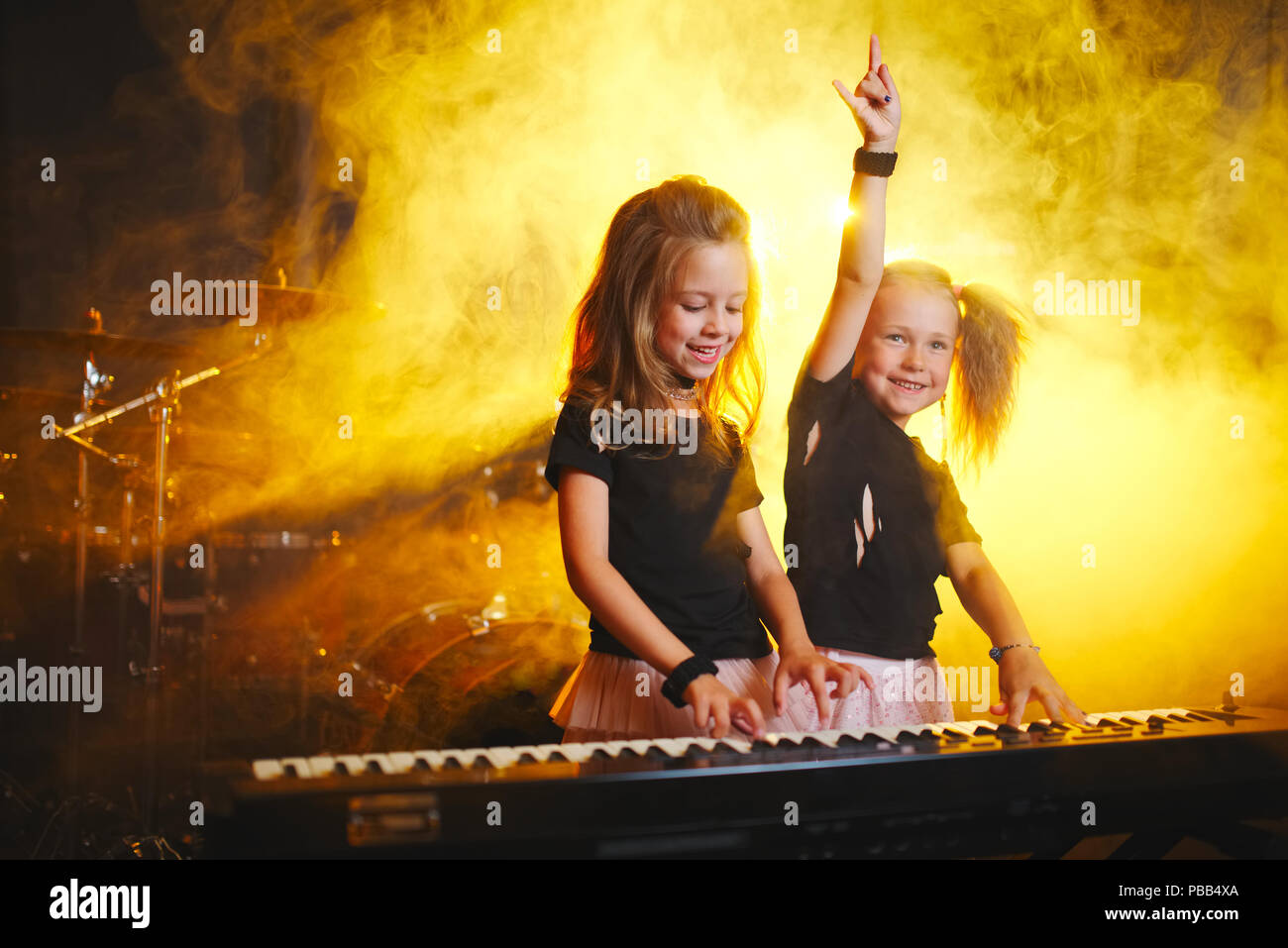 little funny girl play on synthesizer in music studio Stock Photo - Alamy