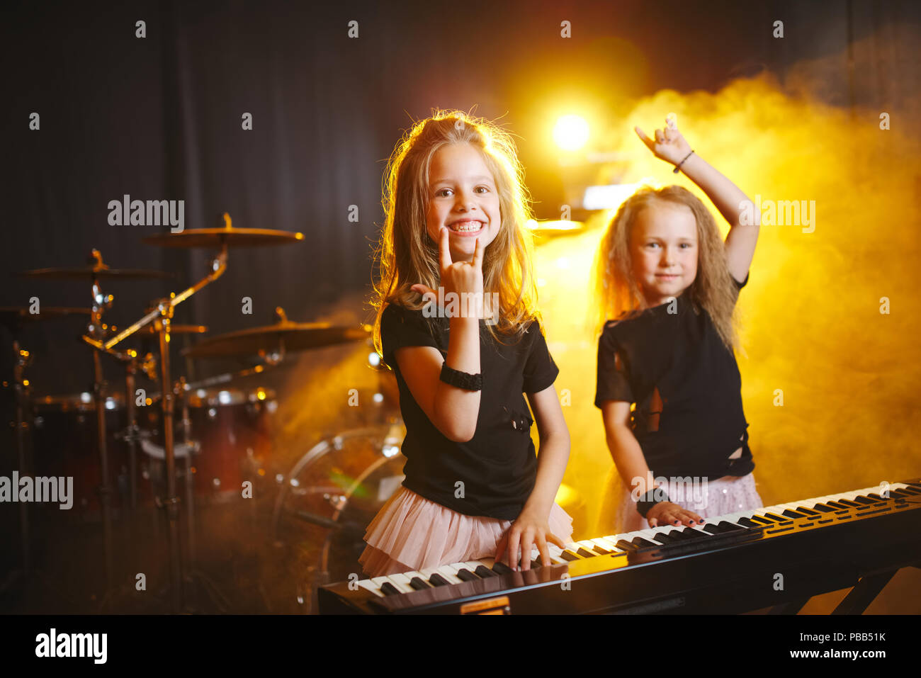 little funny girl play on synthesizer in music studio Stock Photo - Alamy