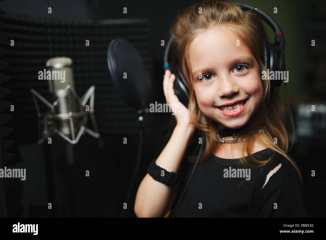 little happy girl singing in recording studio Stock Photo - Alamy